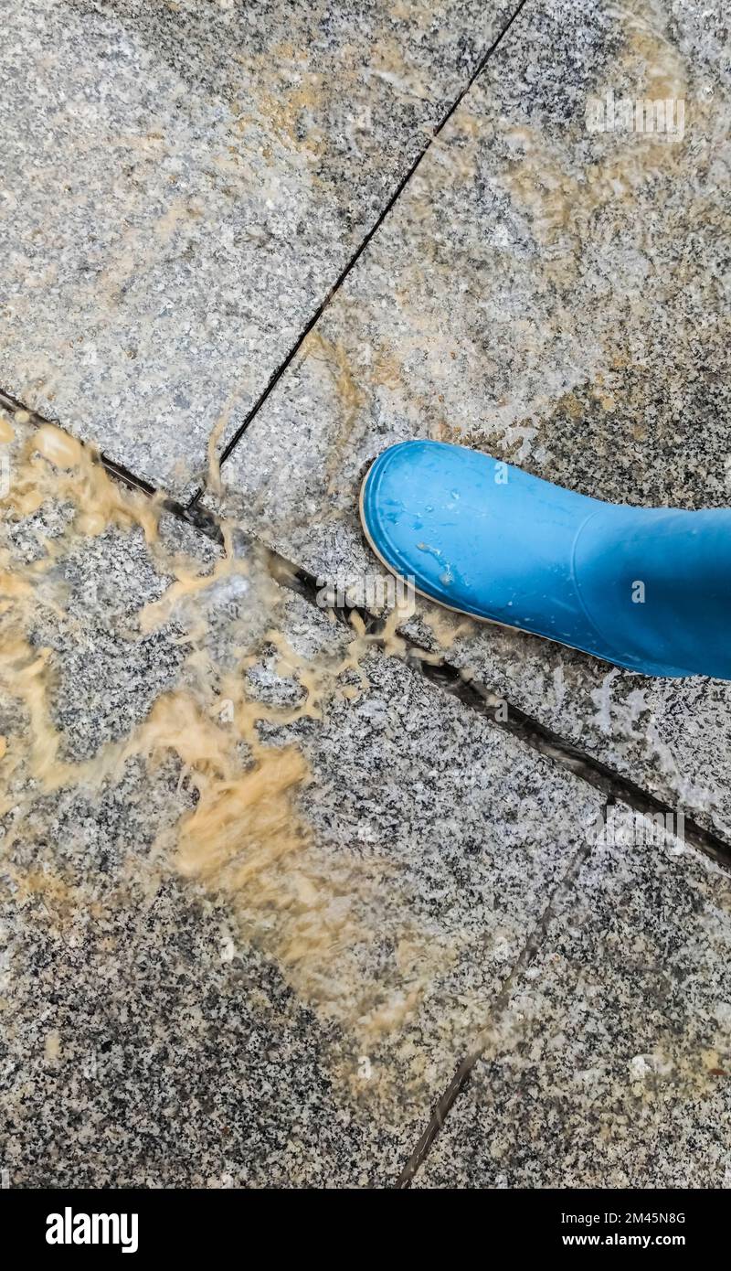 A loose cobblestone splashes on a childs boots when stepped on. High ...