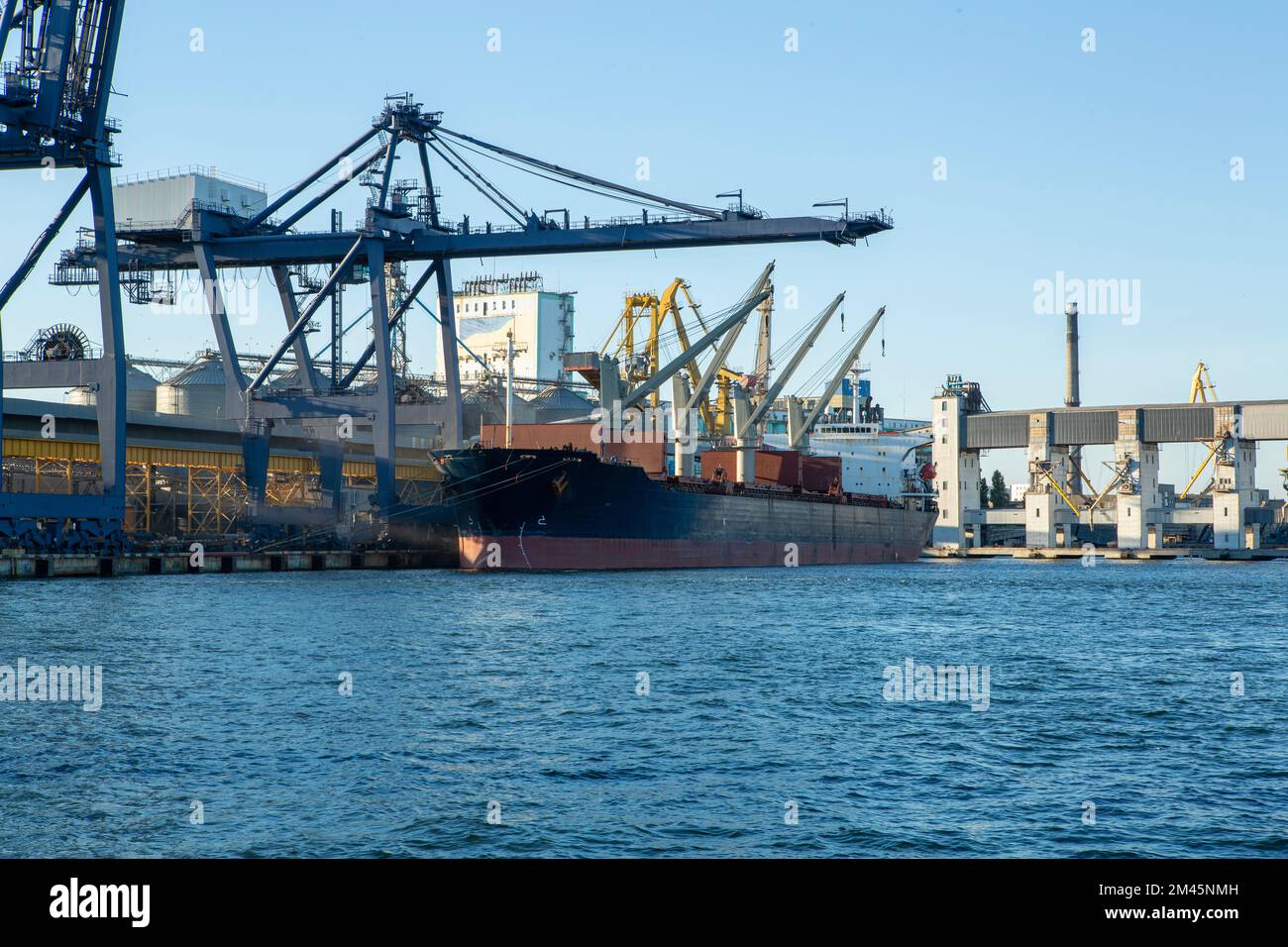 Vessel dry cargo on loading, unloading in port. Bulker in port Stock Photo - Alamy