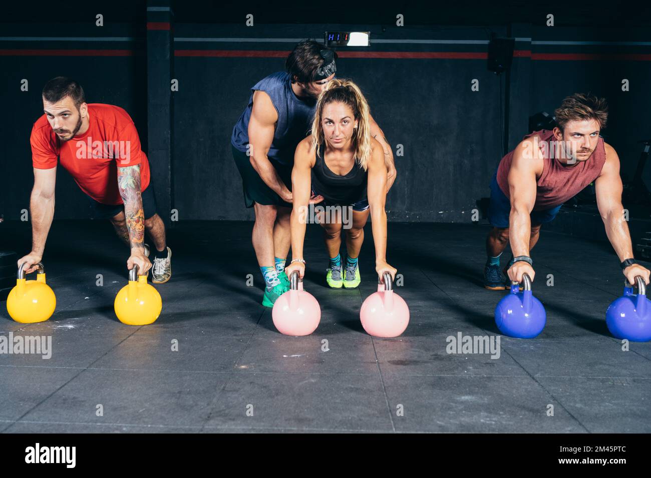 Trainer correcting a woman during a training session in a gymnasium ...