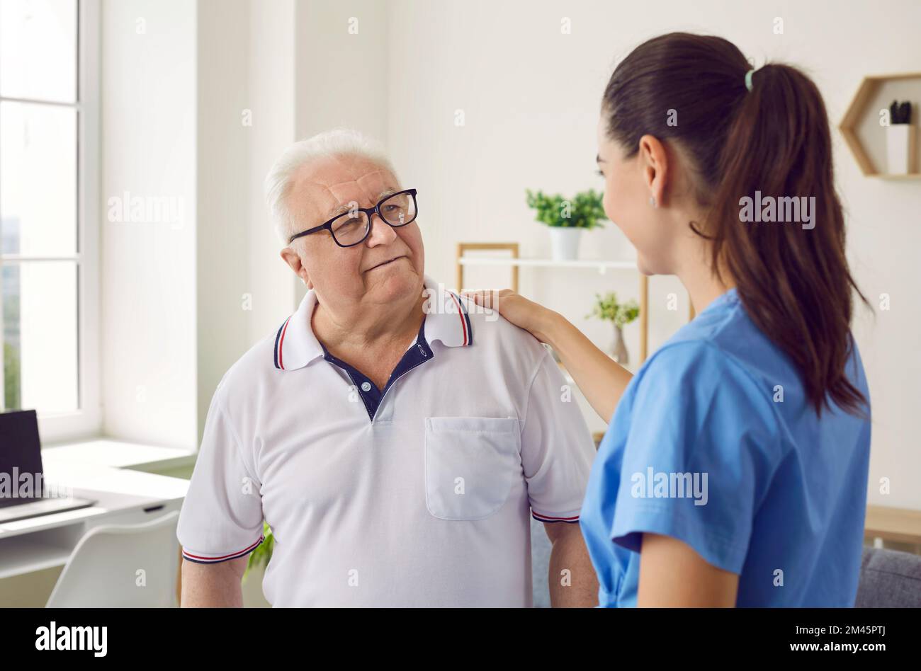 Caring medical nurse comforting senior patient in office Stock Photo ...