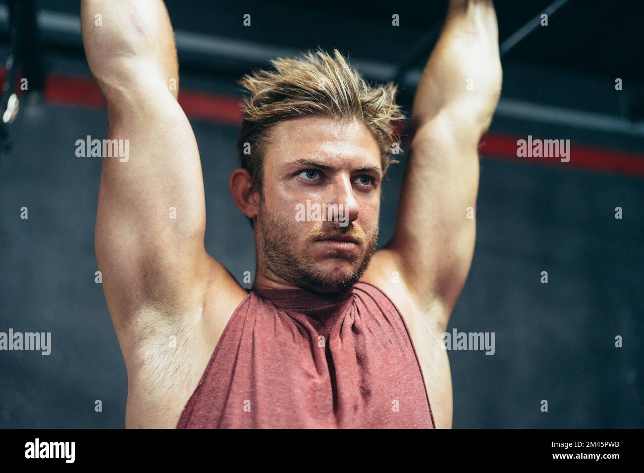 Close up portrait of a concentrated man doing pull ups in a gym Stock ...