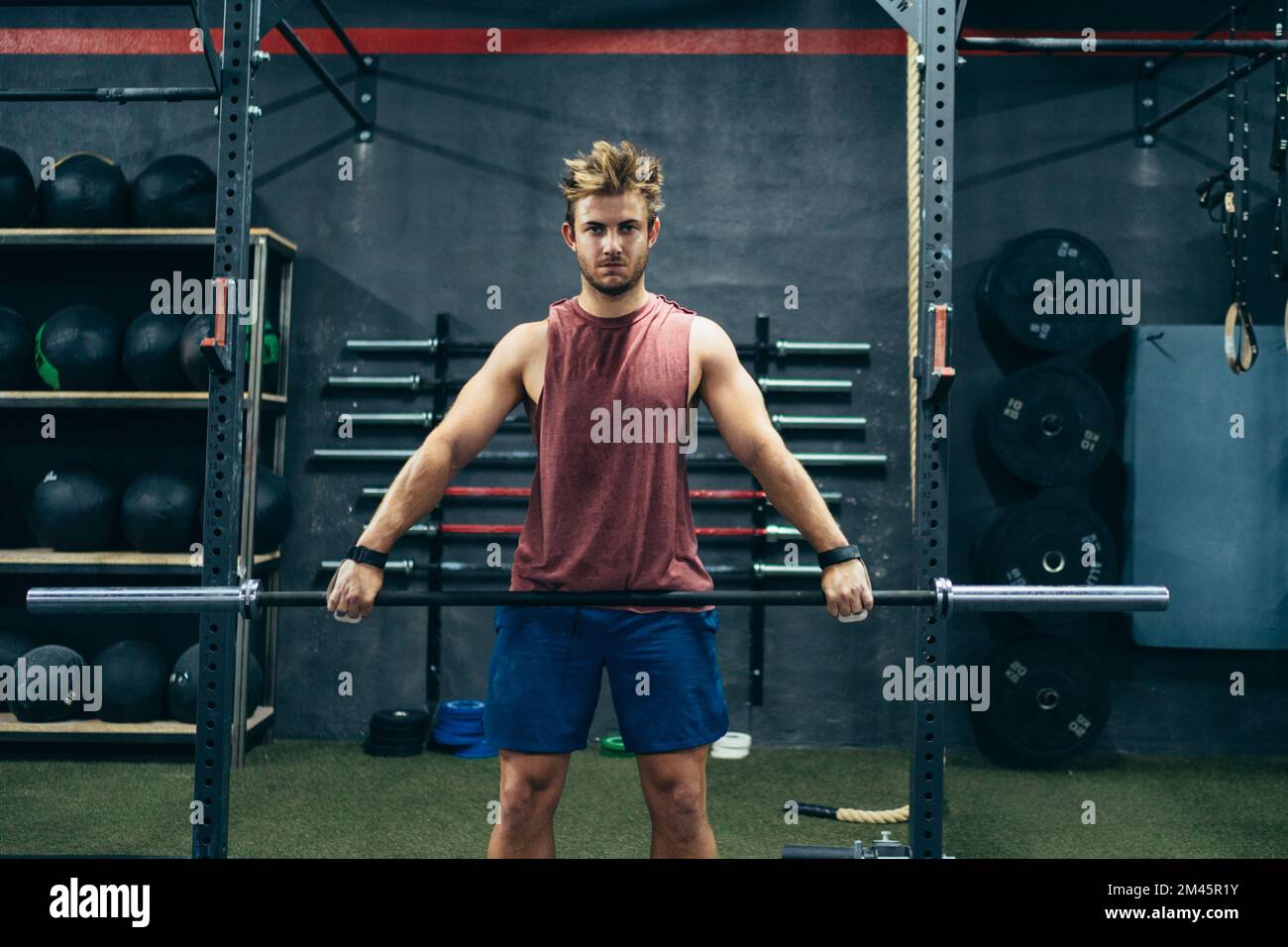 Frontal view of a strong man lifting a barbell in a gym Stock Photo - Alamy