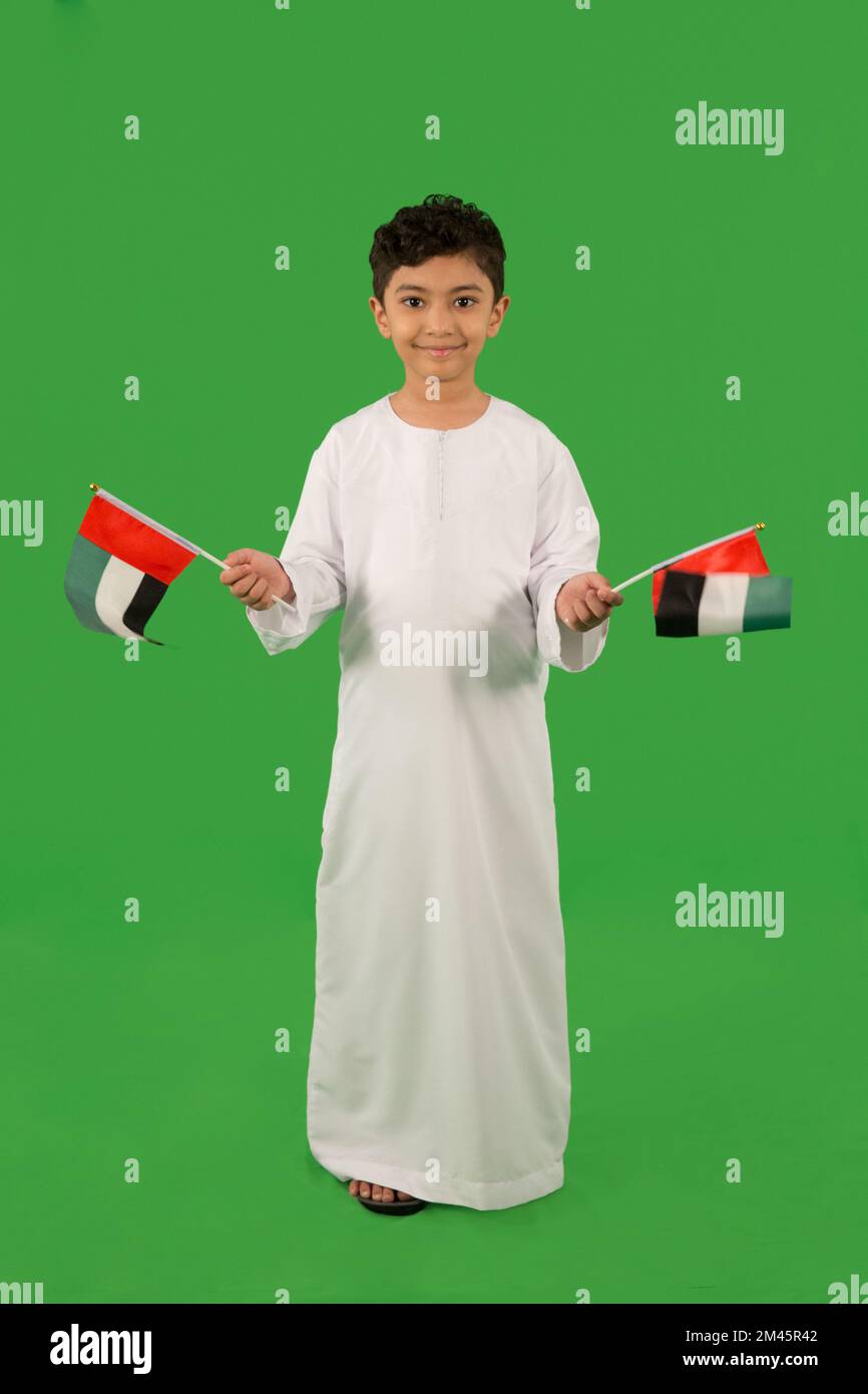 Portrait of an Arab boy holding a UAE national flag Stock Photo - Alamy