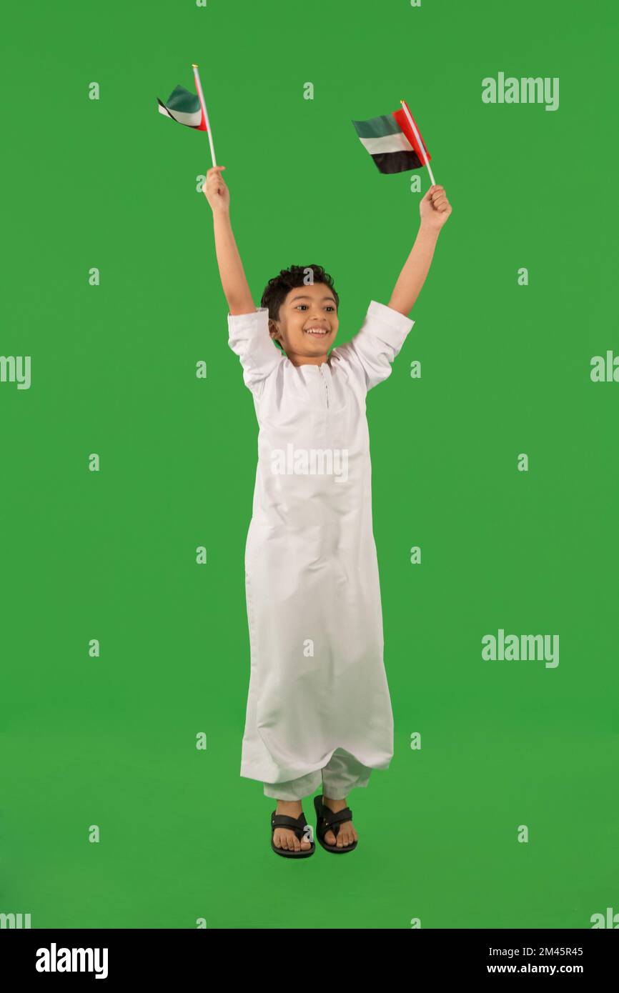 Portrait of an Arab boy holding a UAE national flag Stock Photo - Alamy