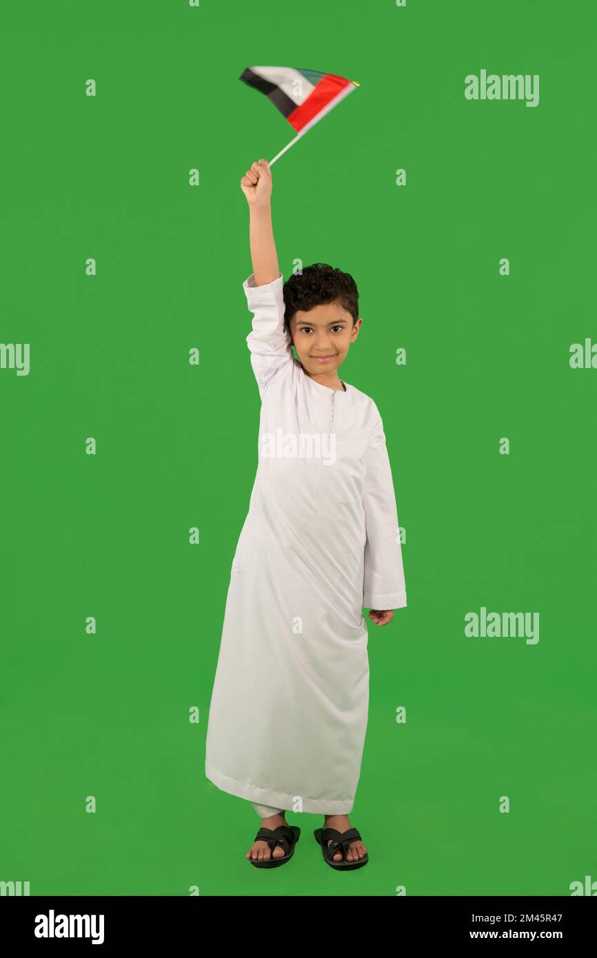 Portrait of an Arab boy holding a UAE national flag Stock Photo - Alamy
