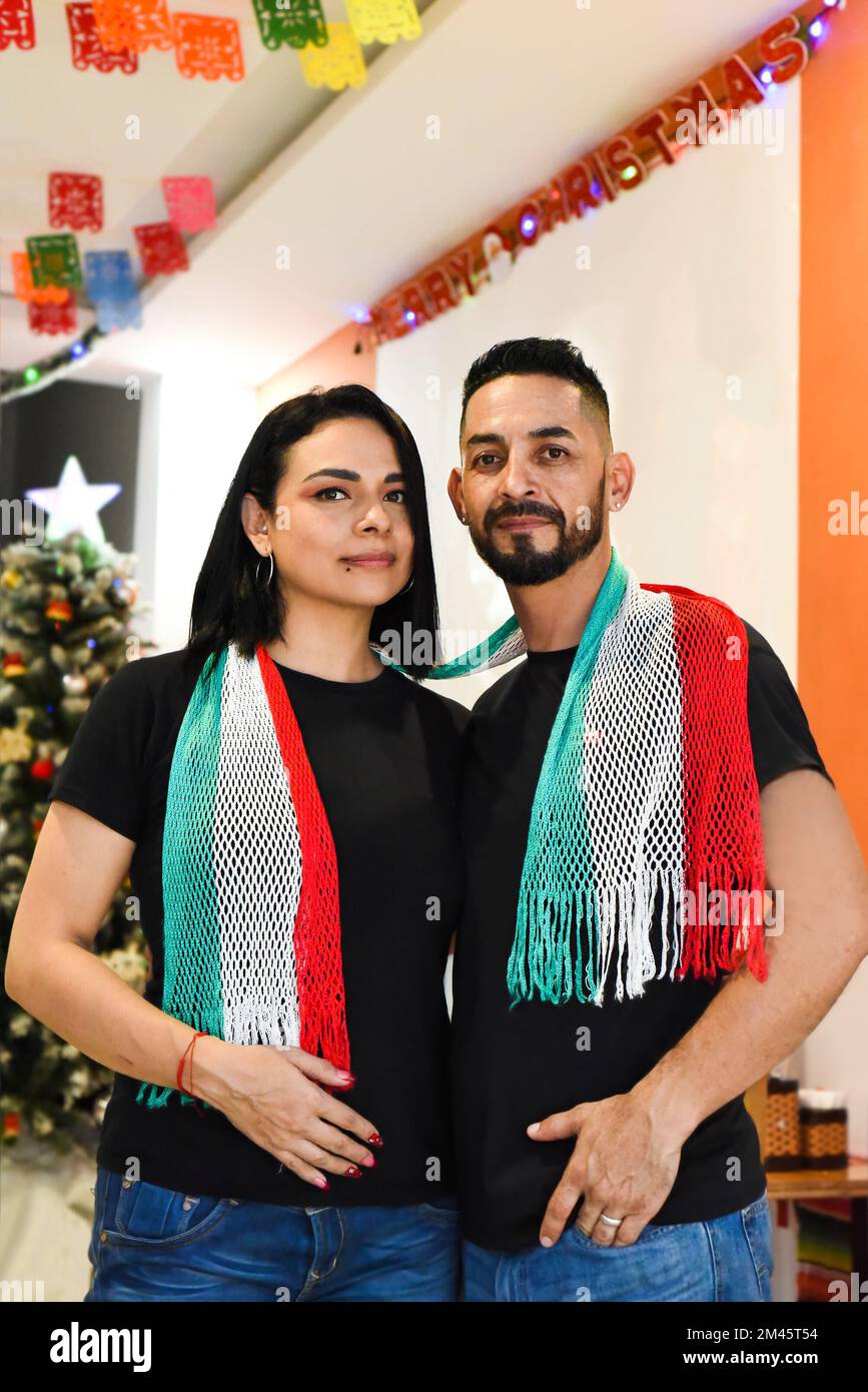 Mexican married couple standing against christmas tree Stock Photo - Alamy