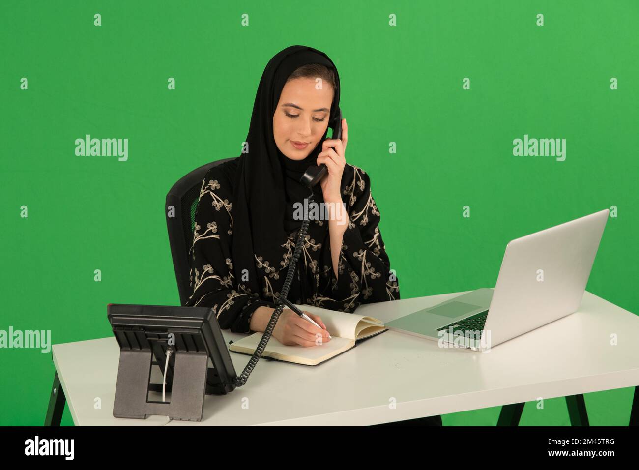 Arab woman talking on telephone in office Stock Photo - Alamy