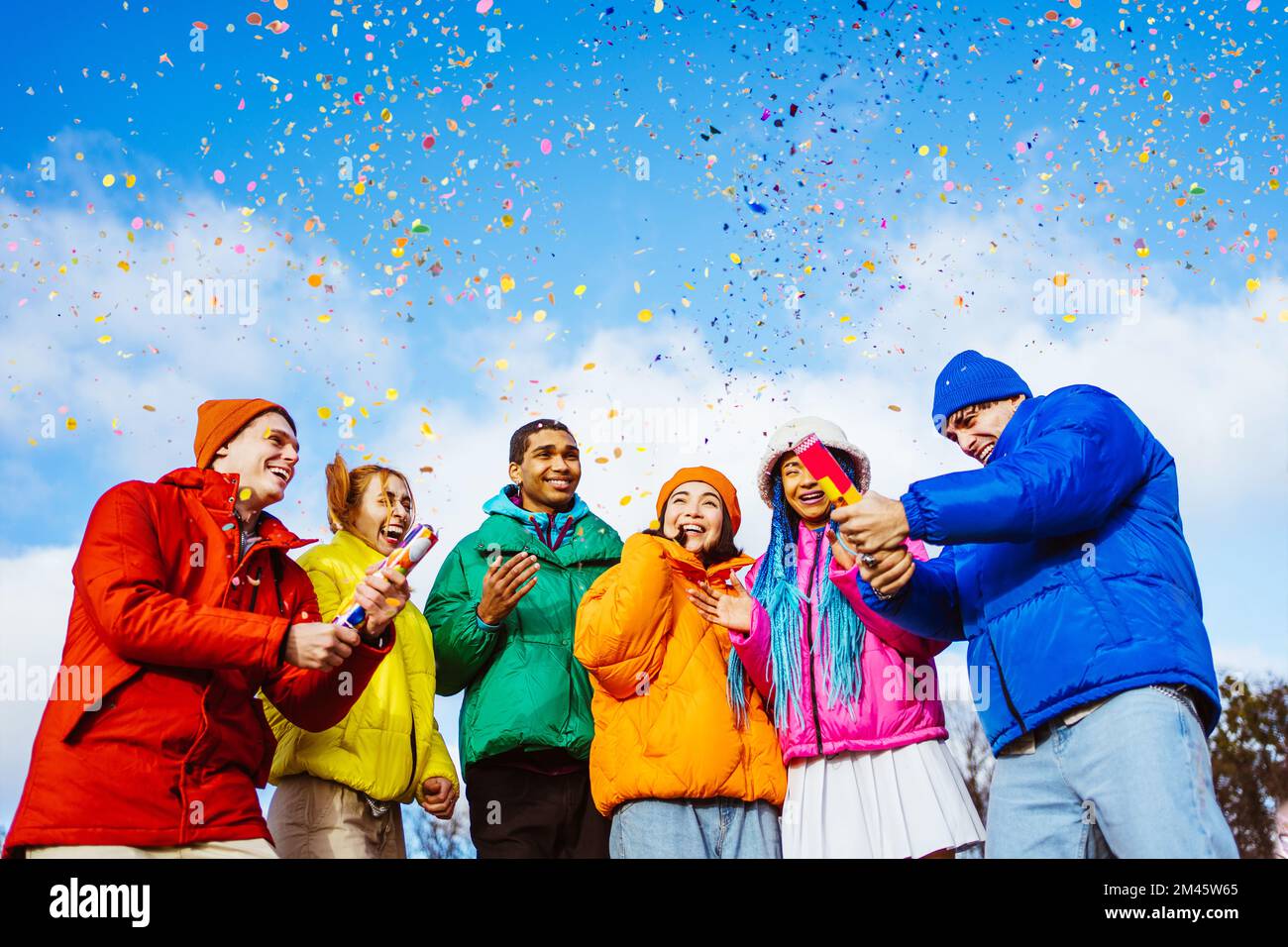 Multiracial group of young happy friends meeting outdoors in winter and ...