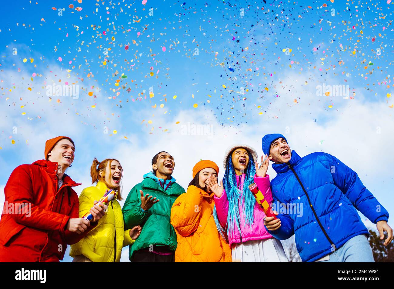 Multiracial group of young happy friends meeting outdoors in winter and ...