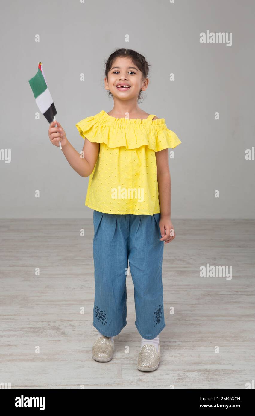 Young girl waving UAE national flag Stock Photo - Alamy
