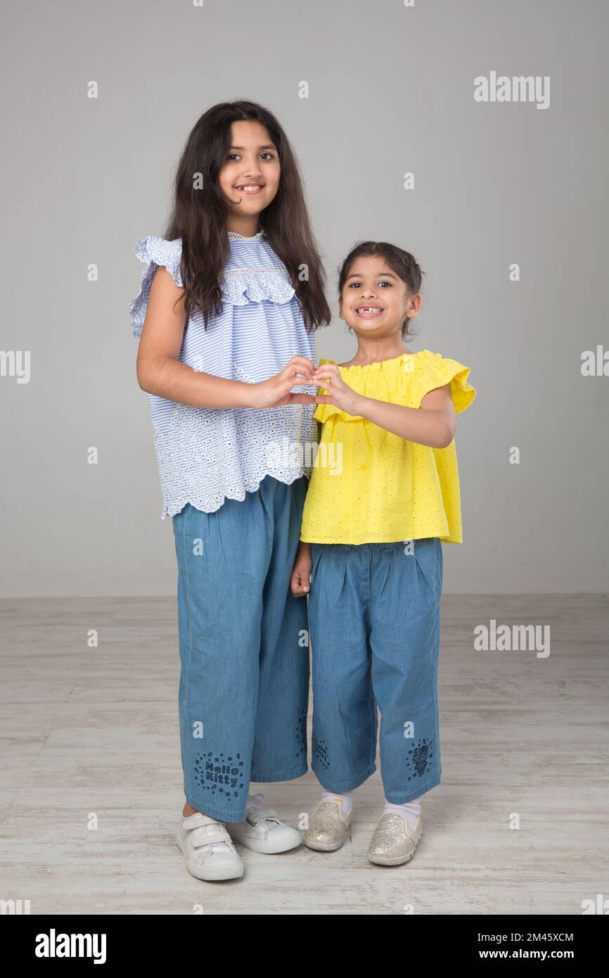 Two girls forming a heart with their hands Stock Photo - Alamy