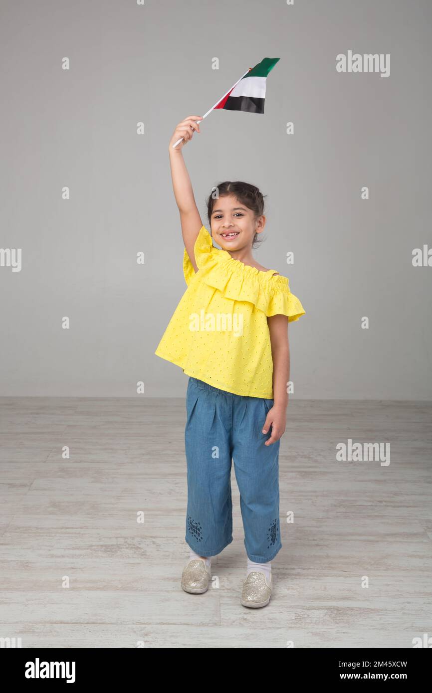 Young girl waving UAE national flag Stock Photo - Alamy