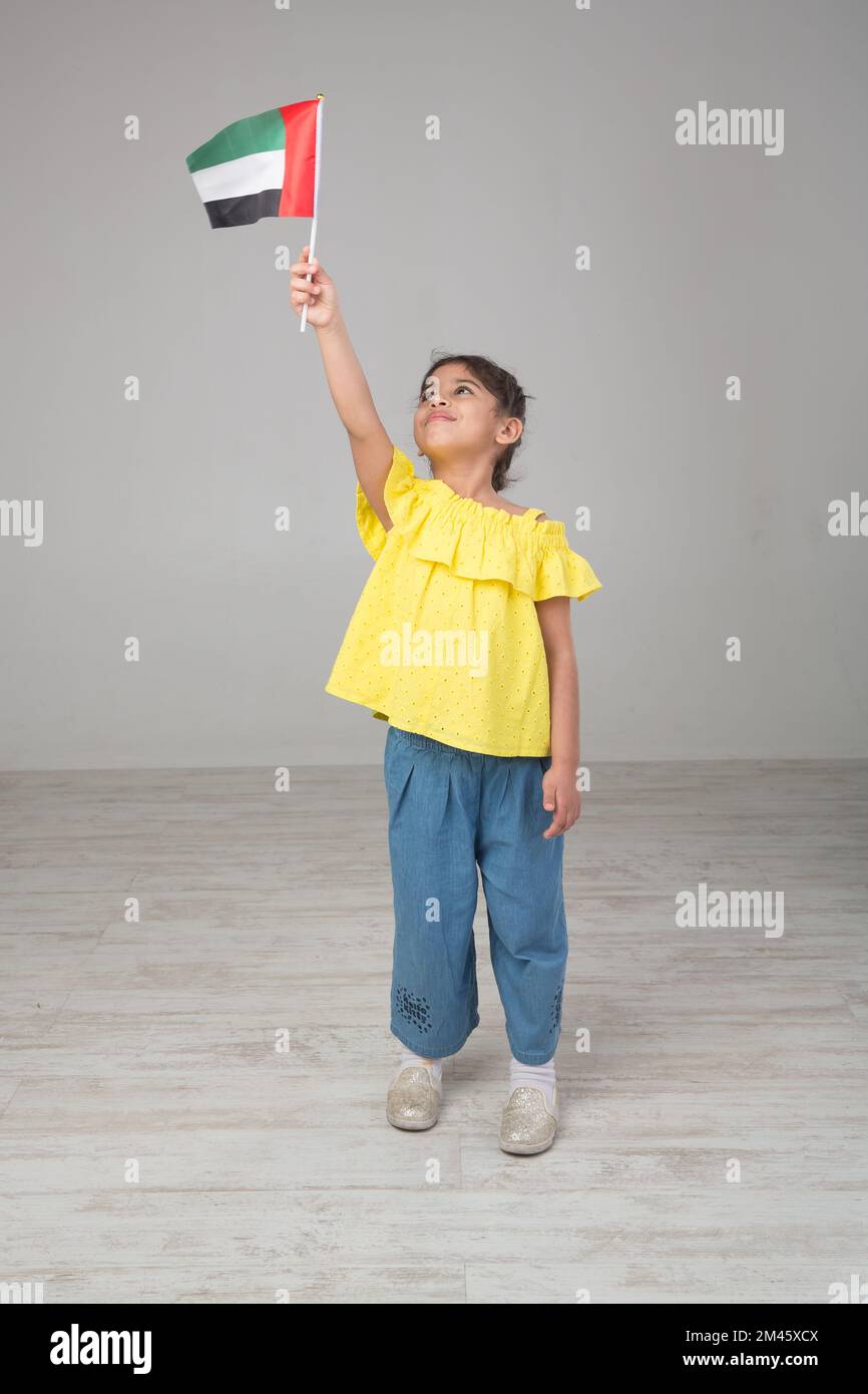 Young girl waving UAE national flag Stock Photo - Alamy