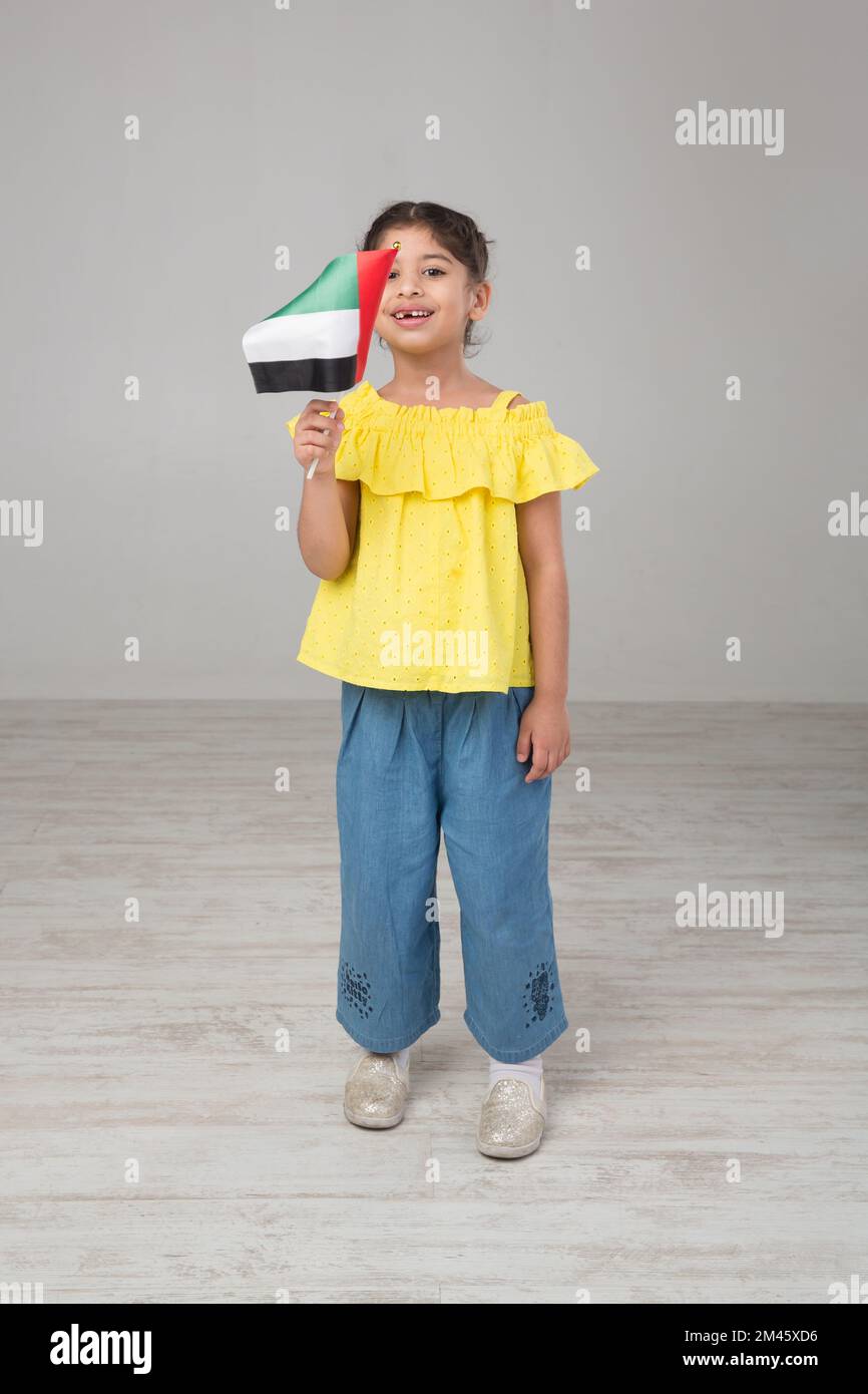 Young girl waving UAE national flag Stock Photo - Alamy