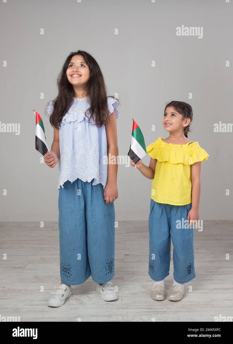 Two girls holding the UAE national flag Stock Photo - Alamy