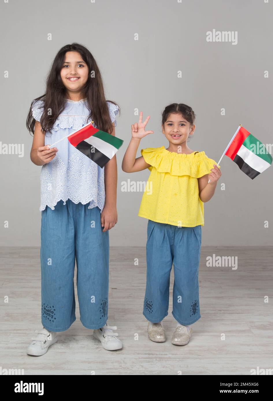Two girls holding the UAE national flag Stock Photo - Alamy