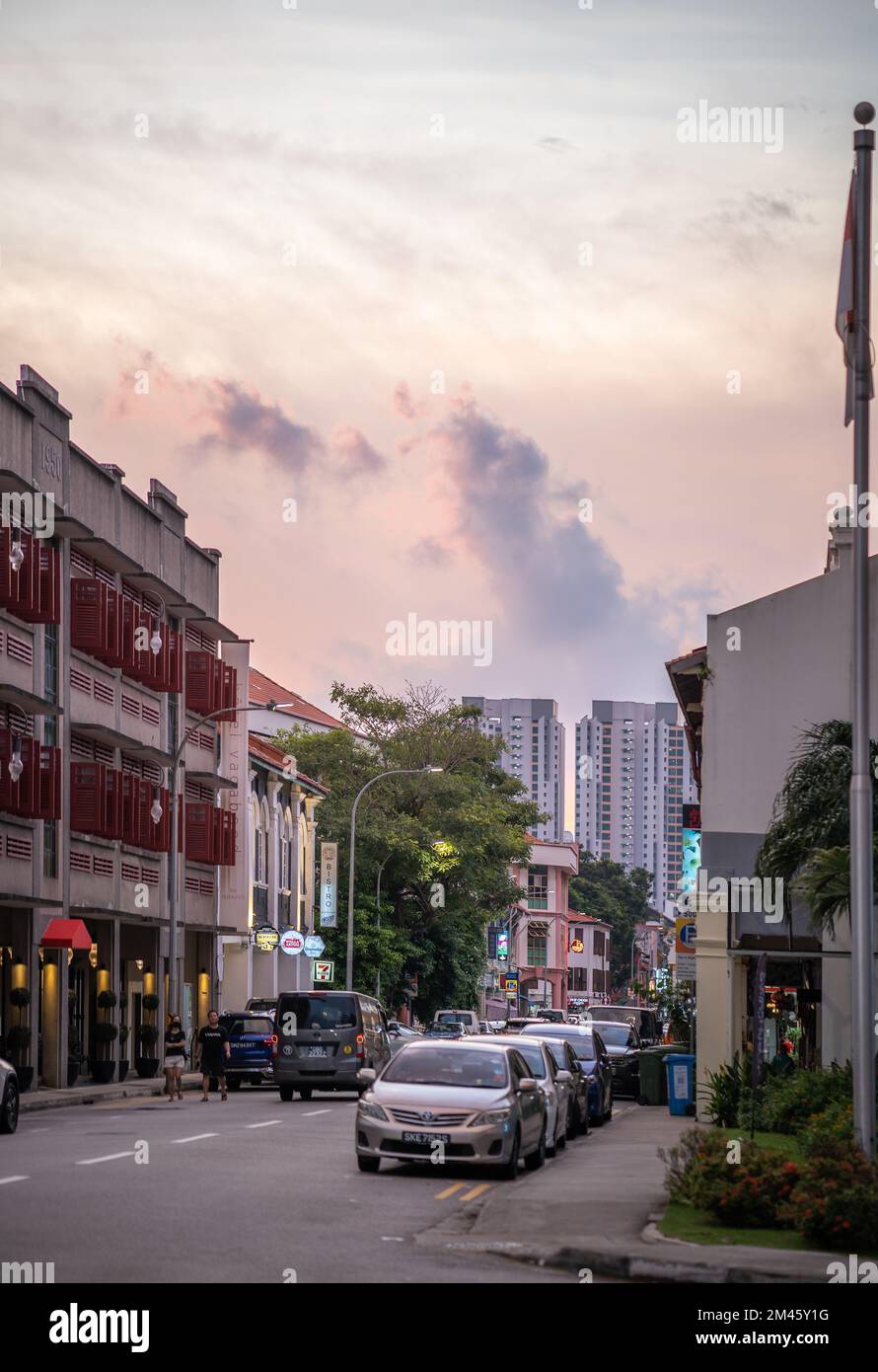 The street of Jalan Besar with parking cars with purple sunset sky ...
