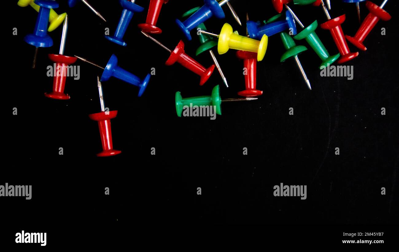 colorful thumbtacks on black background Stock Photo - Alamy