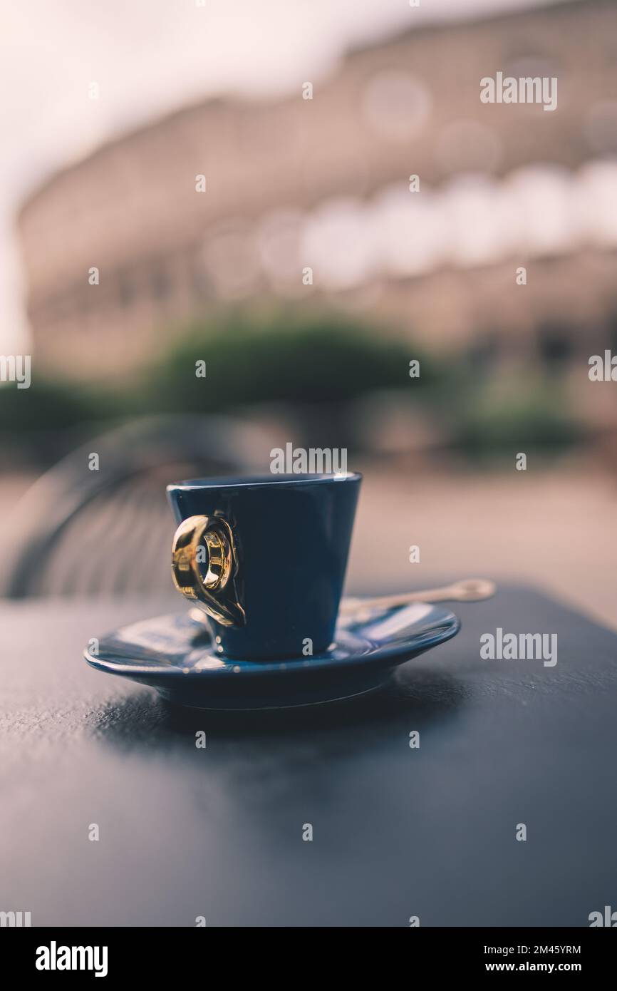A vertical shot of a dark blue coffee cup on a table outside Stock ...