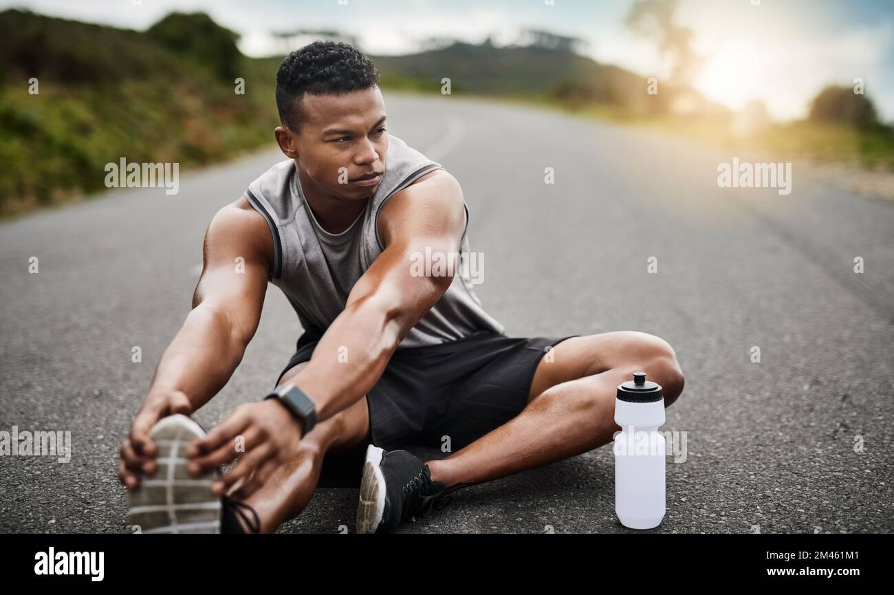 Every workout adds up to something. a sporty young man stretching his ...