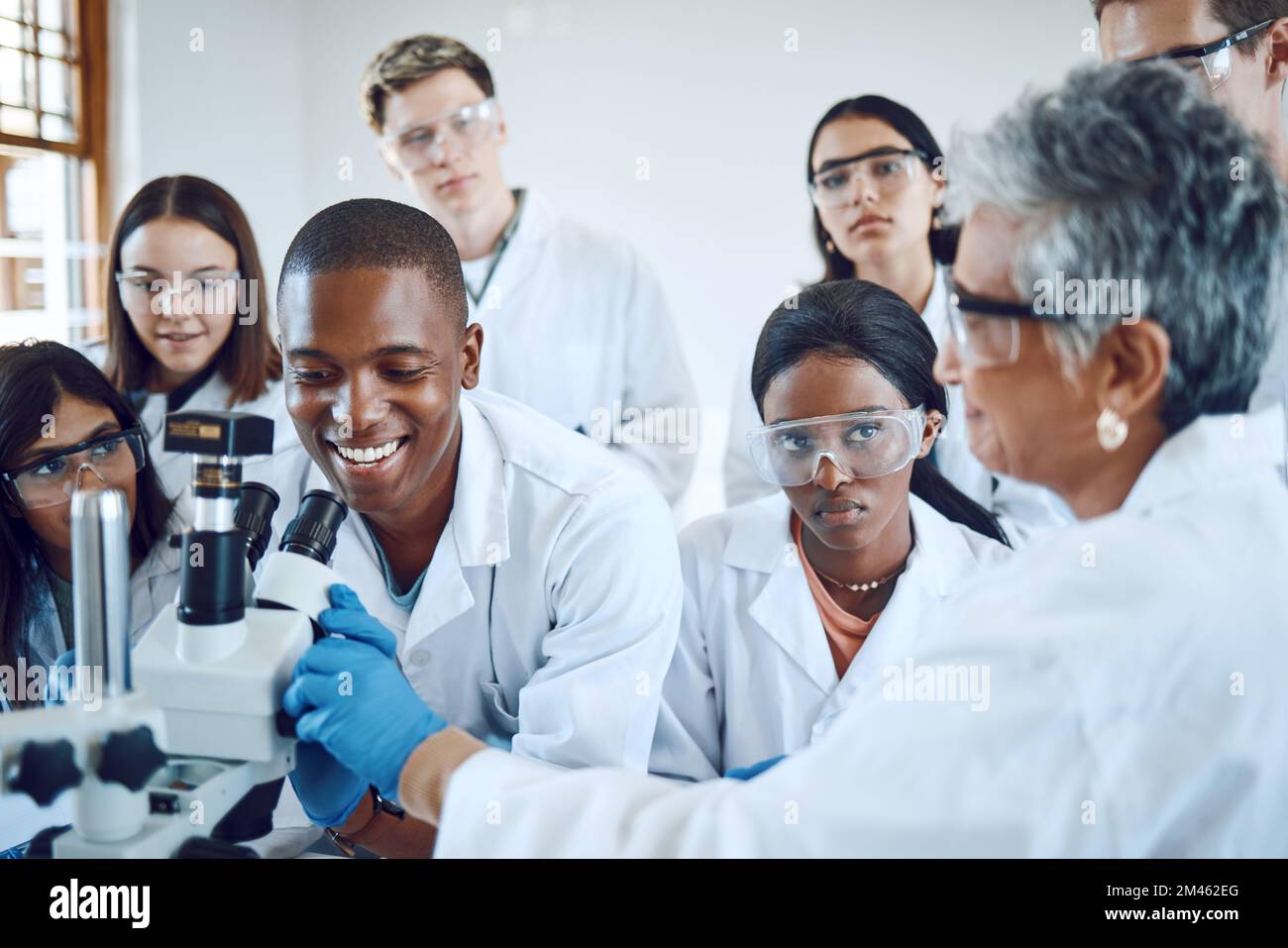 Education, science and teacher with students using microscope for ...