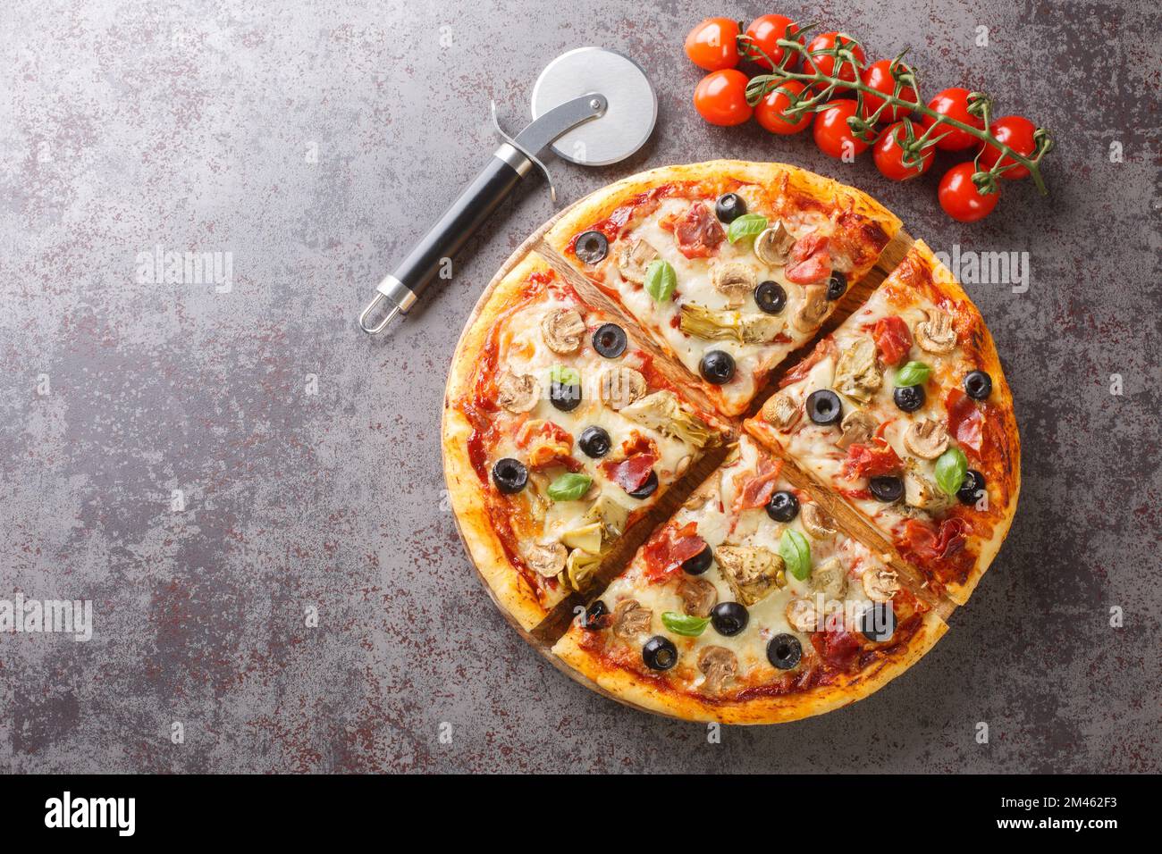 Sliced hot capricciosa pizza with aritichokes, prosciutto ham, olives ...