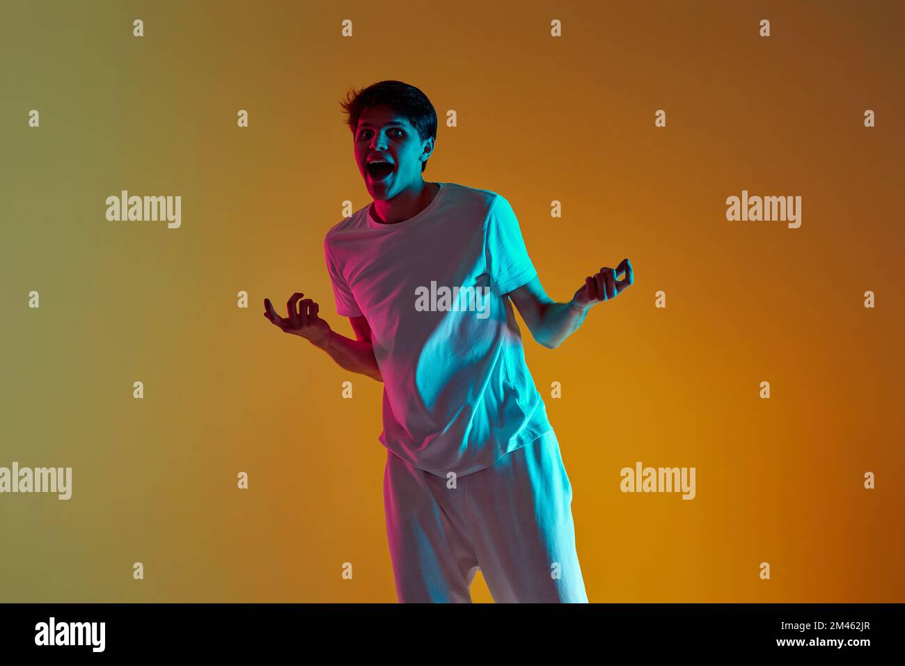 man dancing on yellow background. Neon lighting Stock Photo - Alamy