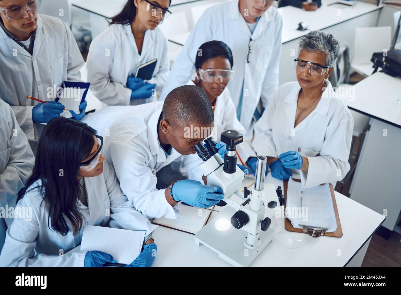 Science, students and medical laboratory with microscope and mentor for ...