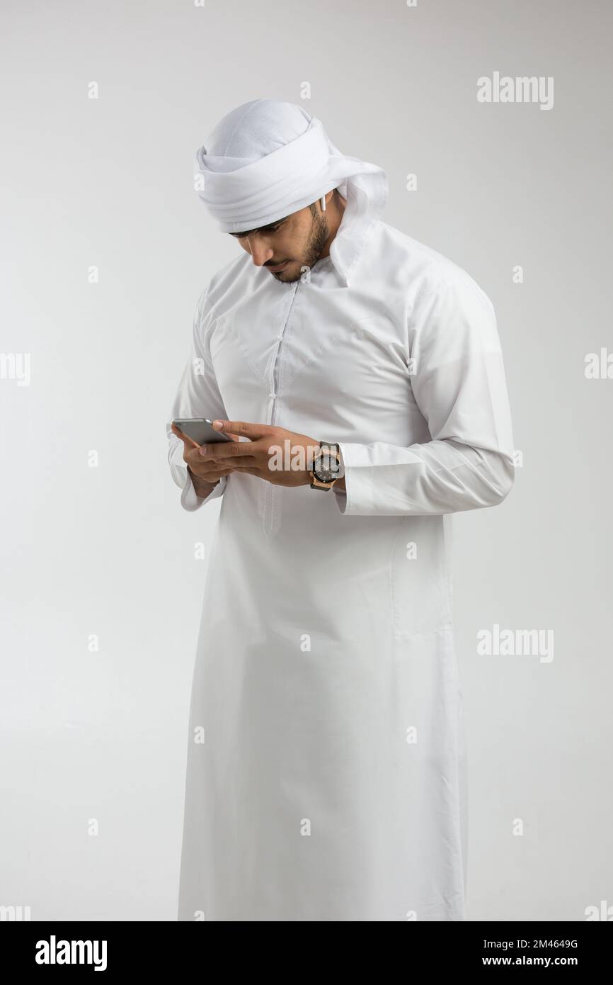 Emirati man texting on his mobile Stock Photo - Alamy