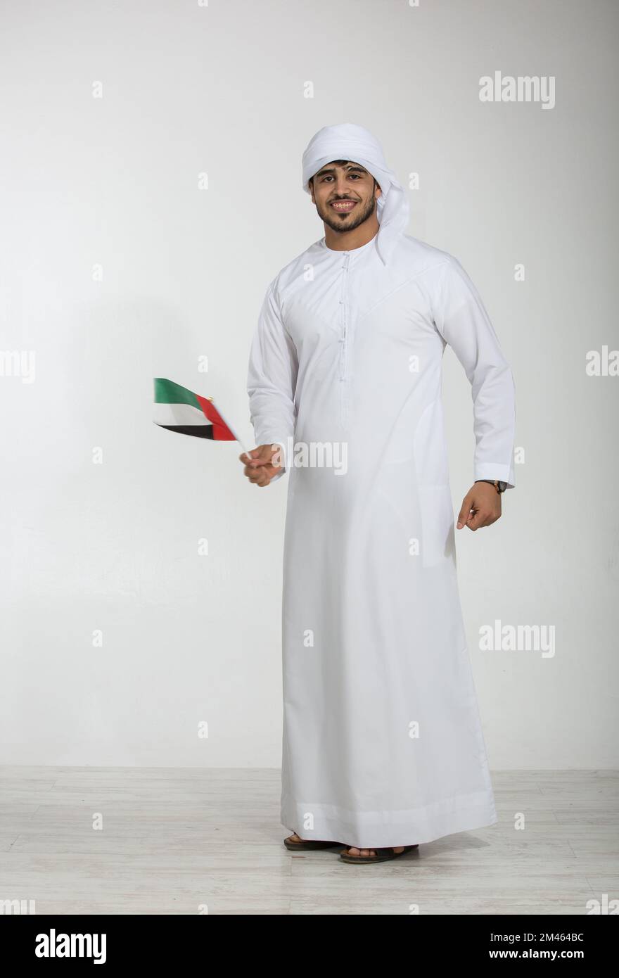 Emirati man holding the UAE national flag Stock Photo - Alamy