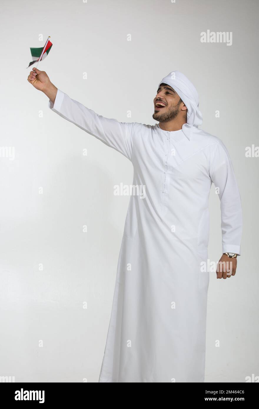 Emirati man holding the UAE national flag Stock Photo - Alamy