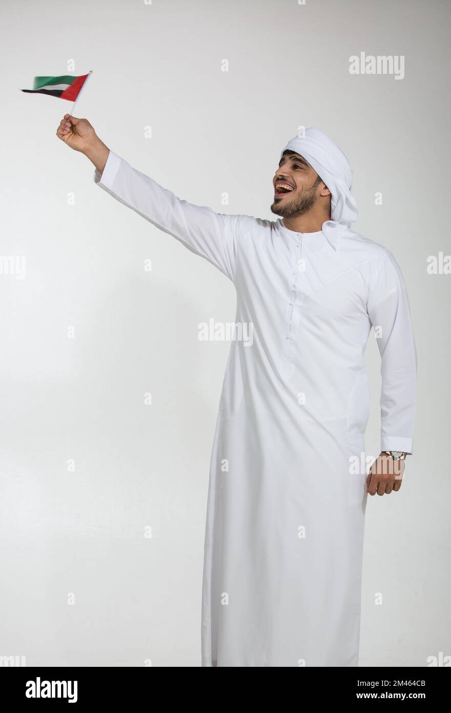 Emirati man holding the UAE national flag Stock Photo - Alamy