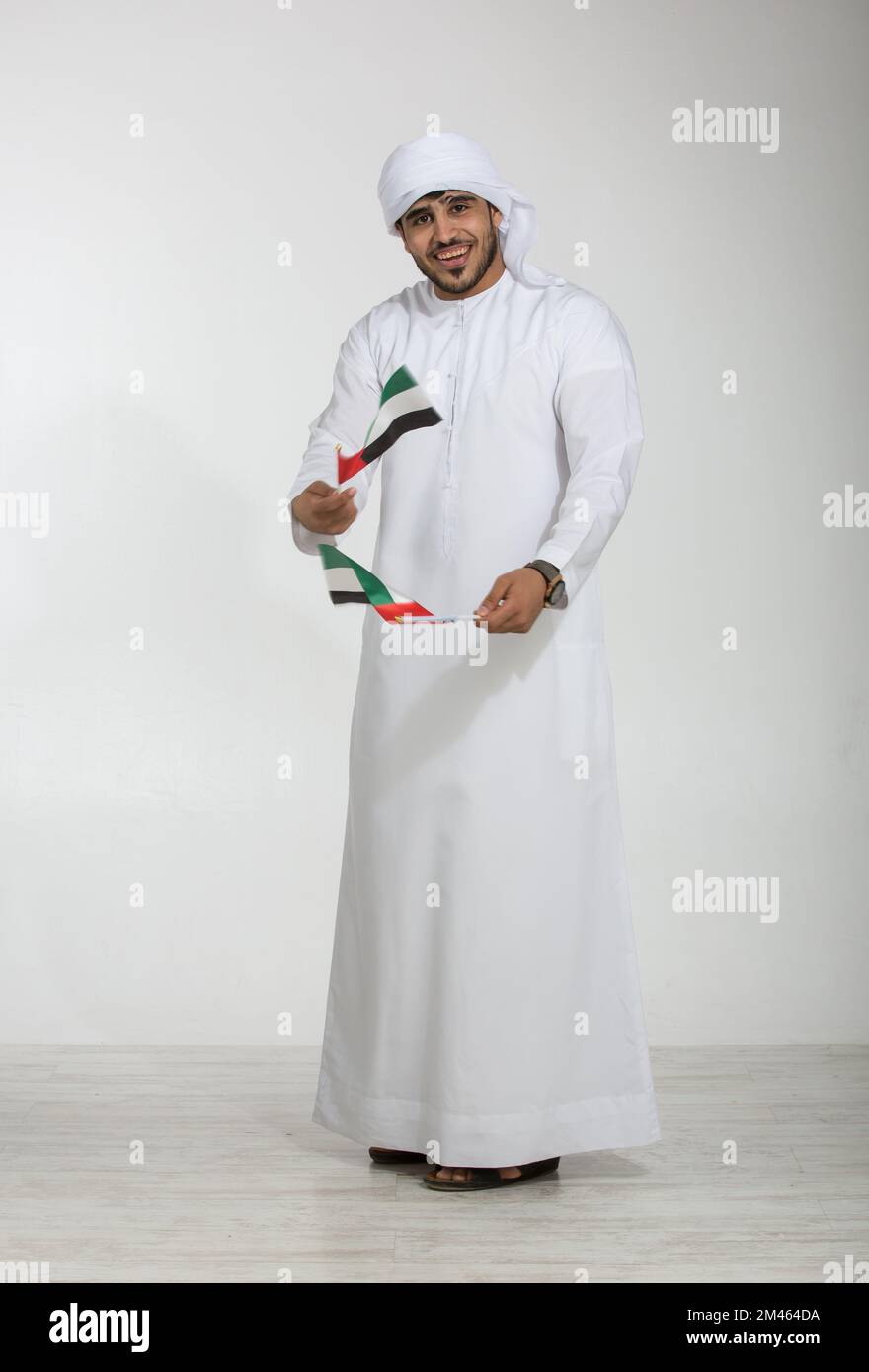 Emirati man holding the UAE national flag Stock Photo - Alamy