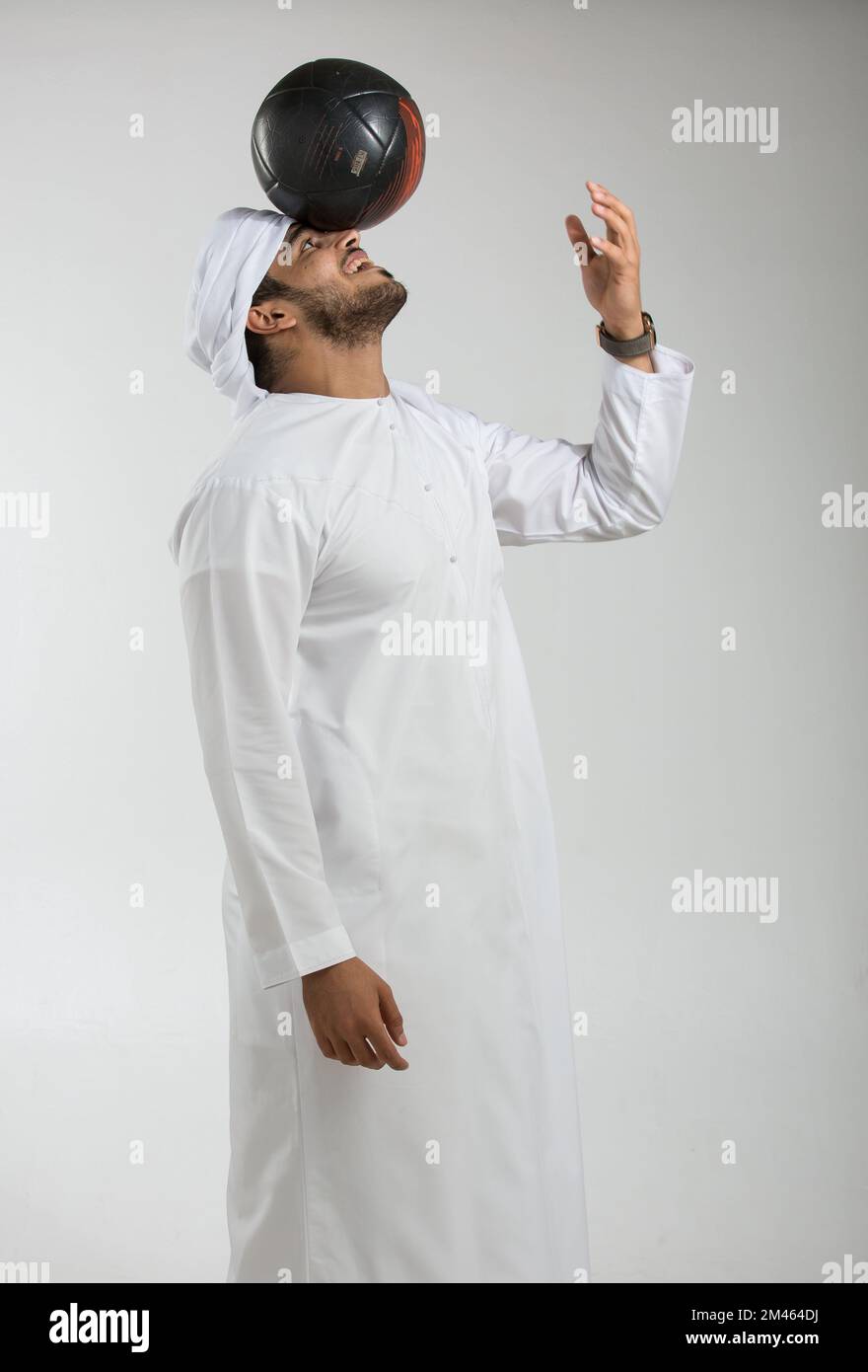 Emirati man playing with football Stock Photo - Alamy
