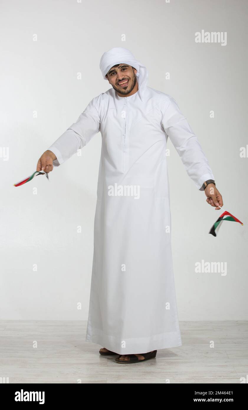 Emirati man holding the UAE national flag Stock Photo - Alamy