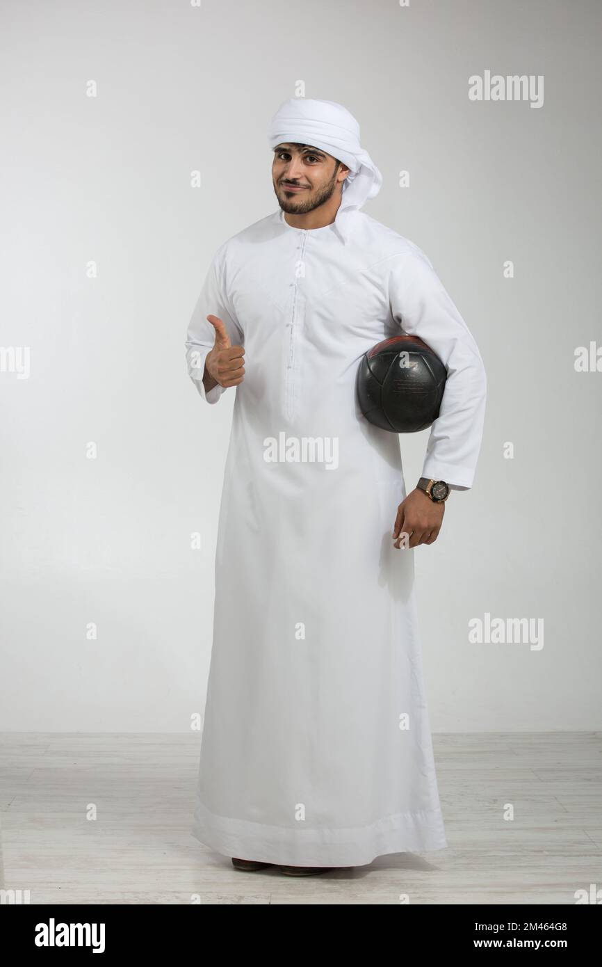 Emirati man playing with football Stock Photo - Alamy