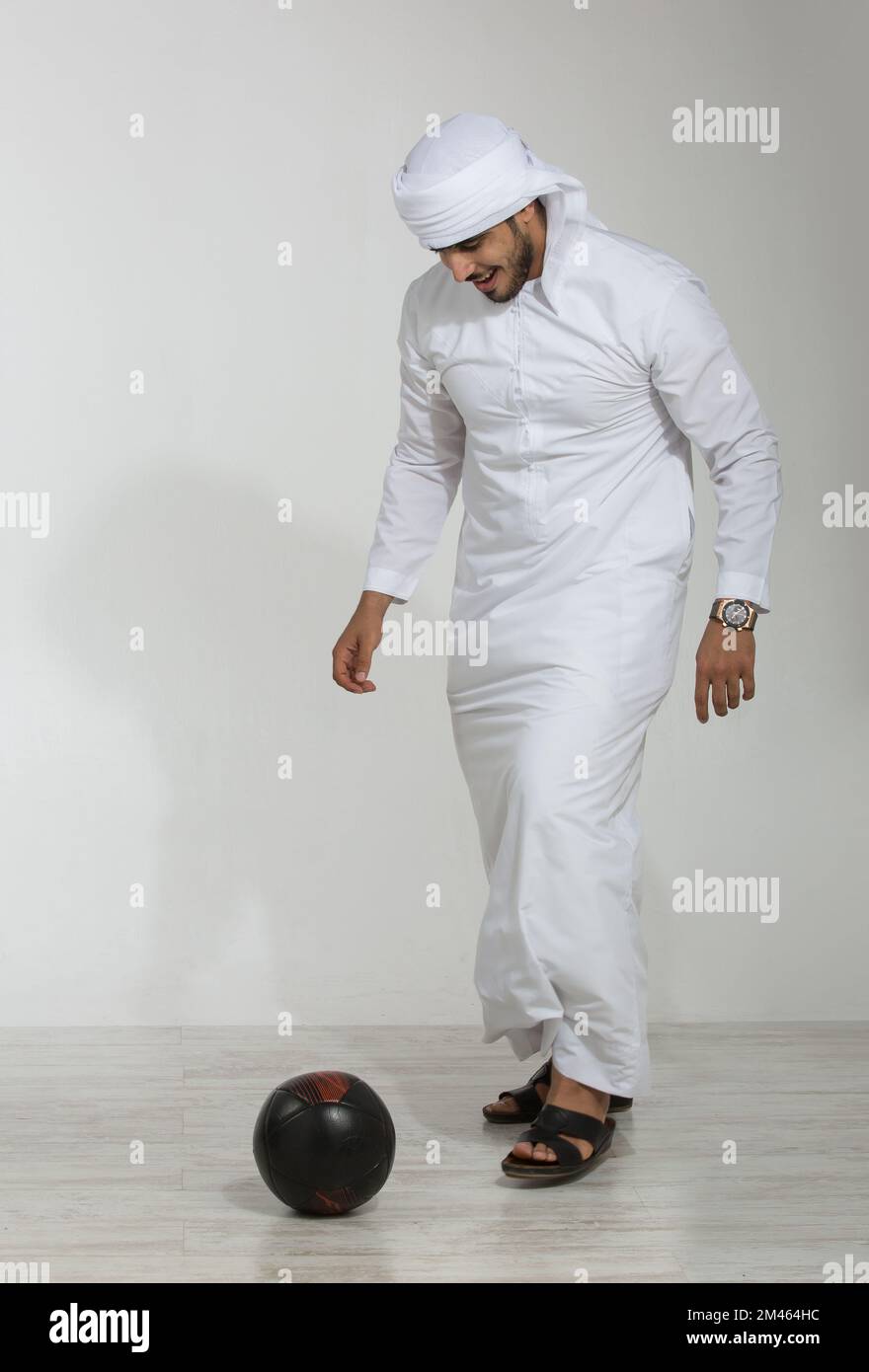 Emirati man playing with football Stock Photo - Alamy