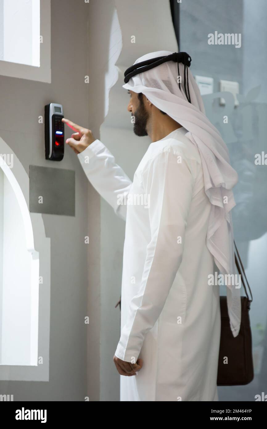 Emirati man using a fingerprint machine Stock Photo - Alamy