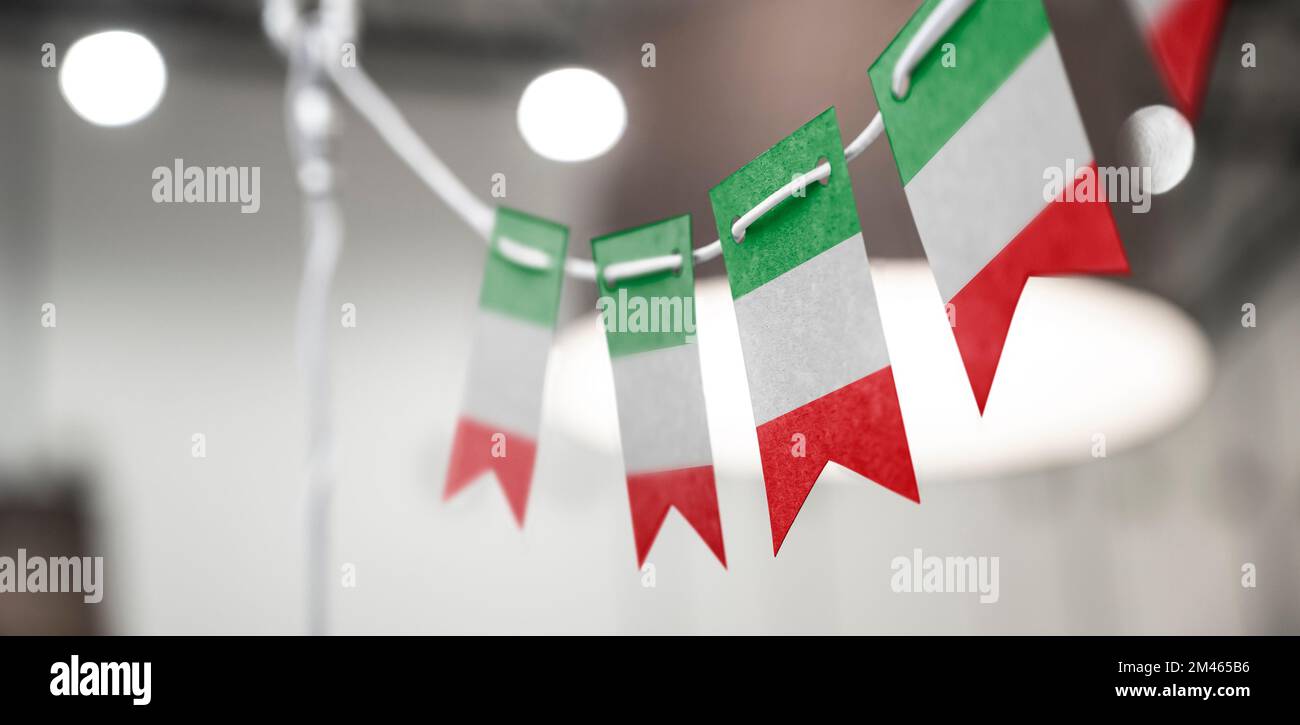 A garland of Italy national flags on an abstract blurred background ...