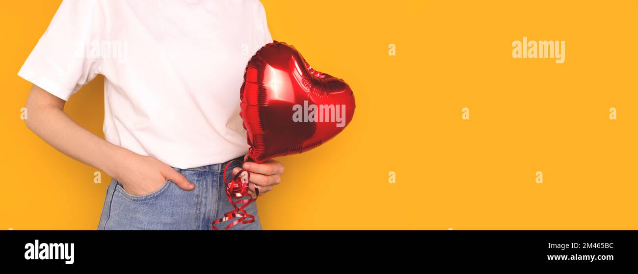 Banner with unrecognizable person hold in hands red inflatable foil ...