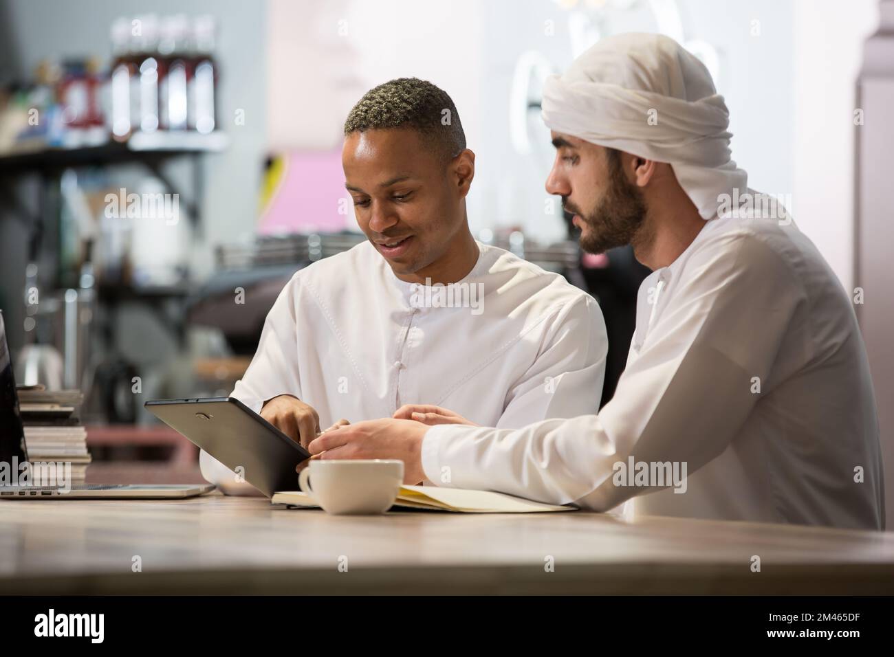 Emirati men working in a cafe Stock Photo - Alamy