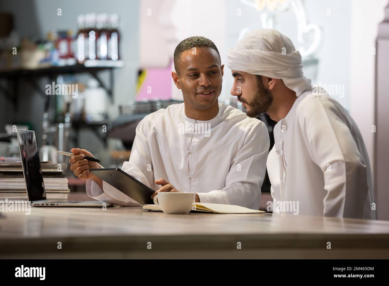 Emirati men working in a cafe Stock Photo - Alamy