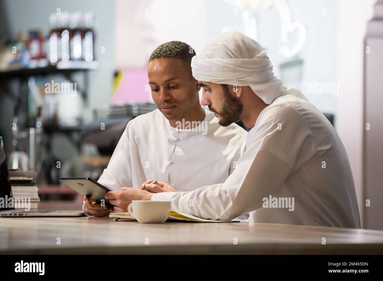 Emirati men working in a cafe Stock Photo - Alamy
