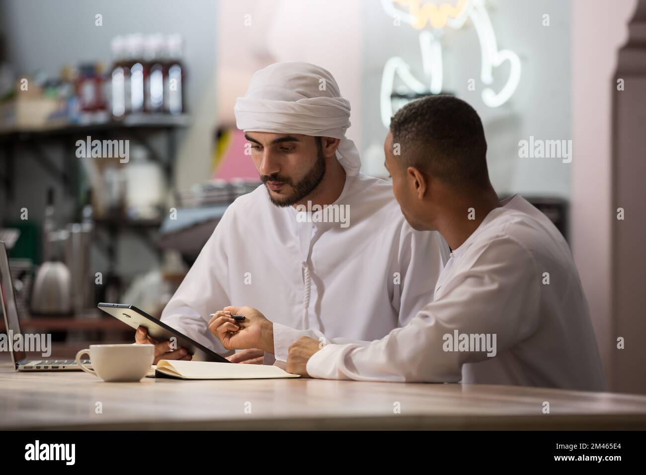 Emirati men working in a cafe Stock Photo - Alamy
