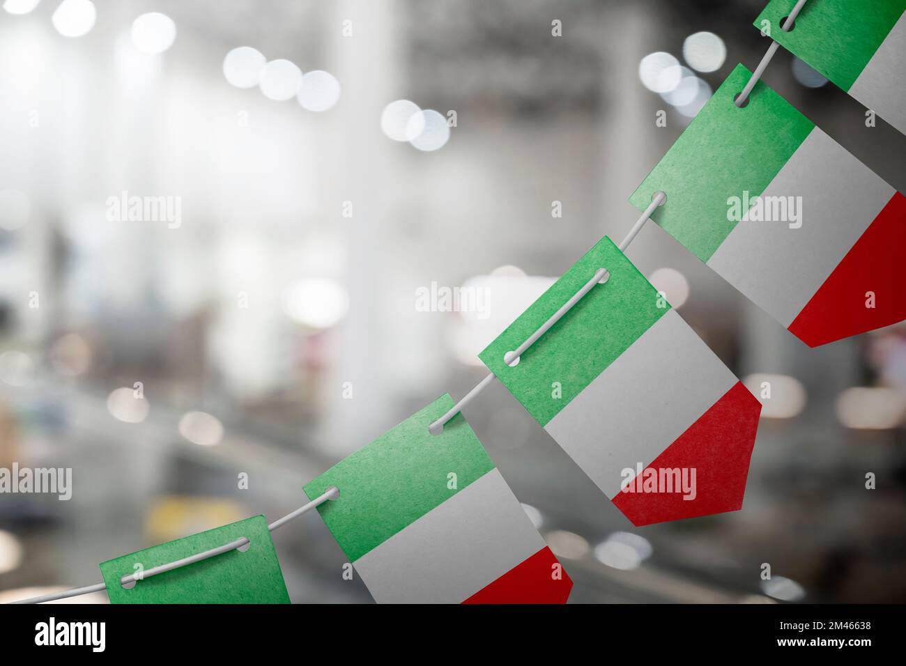 A garland of Italy national flags on an abstract blurred background ...