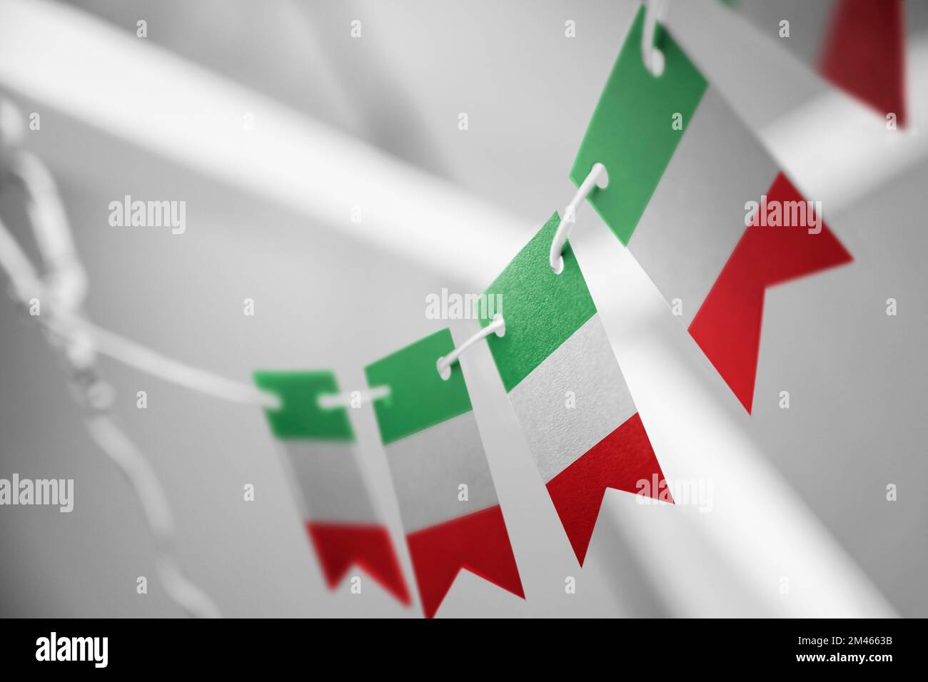 A garland of Italy national flags on an abstract blurred background ...