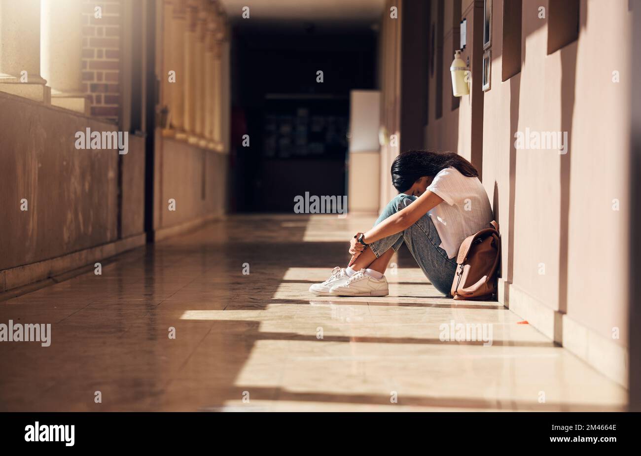 Sad, lonely and girl with depression at school, crying and anxiety ...