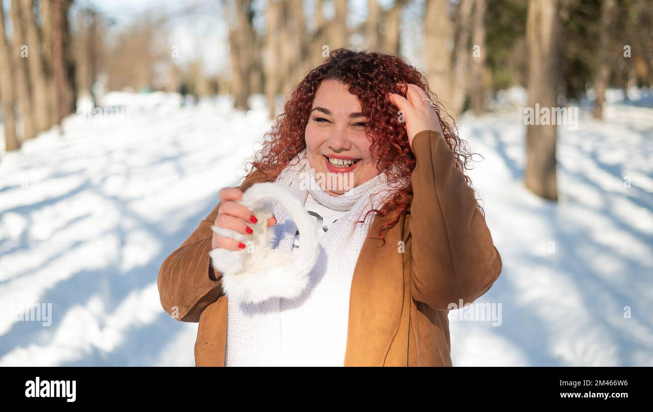 Cheerful fat caucasian woman in fur headphones outdoors Stock Photo - Alamy