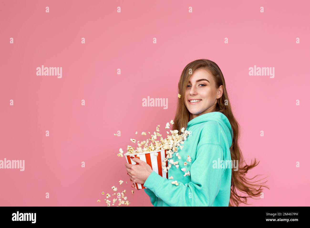 woman holding bucket of popcorn and jumping Stock Photo - Alamy