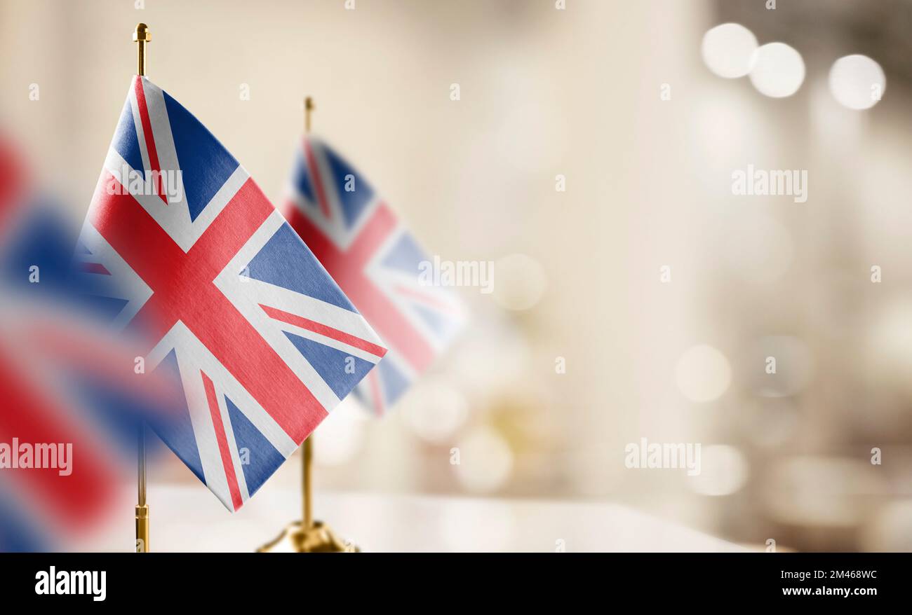 Small flags of the United Kingdom on an abstract blurry background ...